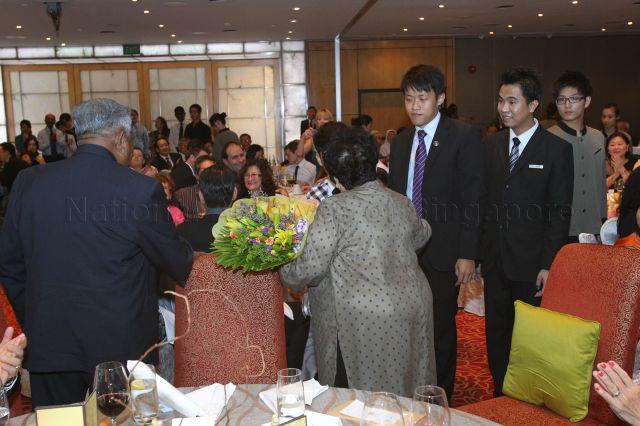 Mrs S R Nathan (back to camera) being presented with a
