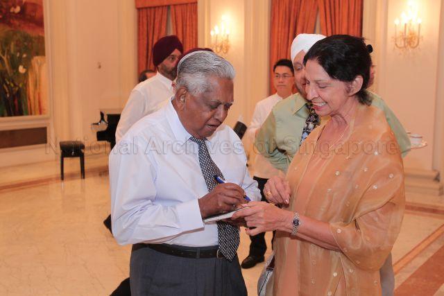 President S R Nathan signing autograph for guest at the