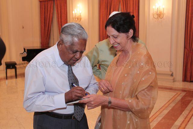 President S R Nathan signing autograph for guest at the