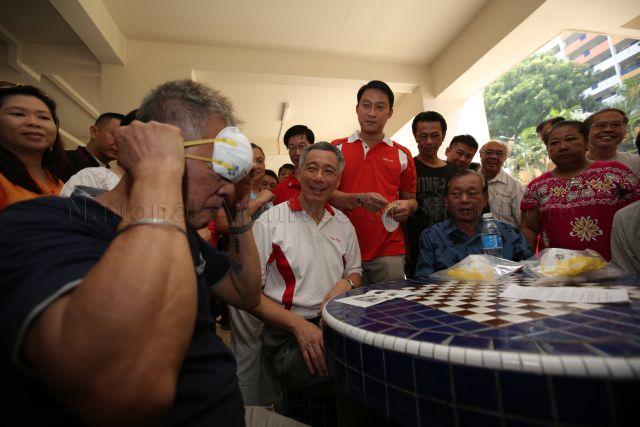 Prime Minister Lee Hsien Loong distributing masks to