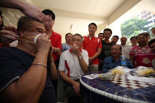 Prime Minister Lee Hsien Loong distributing masks to