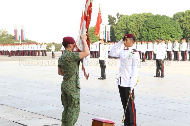 An award recipient with the State Colours at Singapore Armed