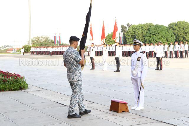 An award recipient with the State Colours at Singapore Armed