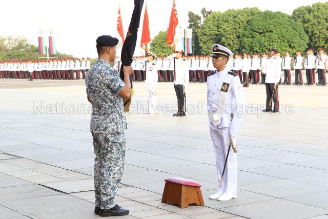 An award recipient with the State Colours at Singapore Armed