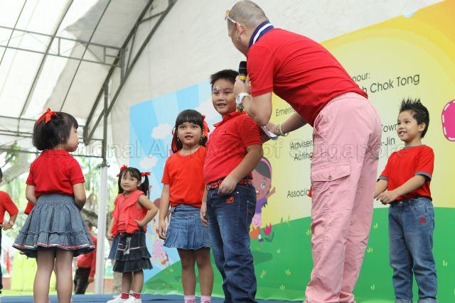 An emcee speaking while on stage with children performers