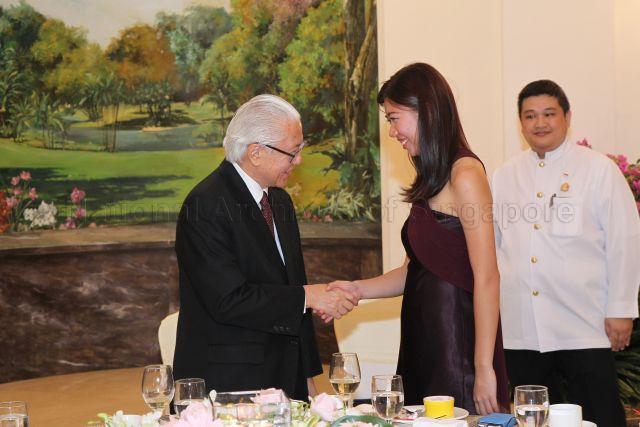 President Tony Tan is shaking hands with Stephanie Siow Su