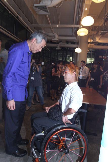 Prime Minister Lee Hsien Loong speaking to paralympian Jovin