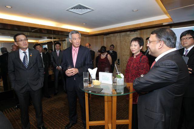Prime Minister Lee Hsien Loong interacting with (in red tie