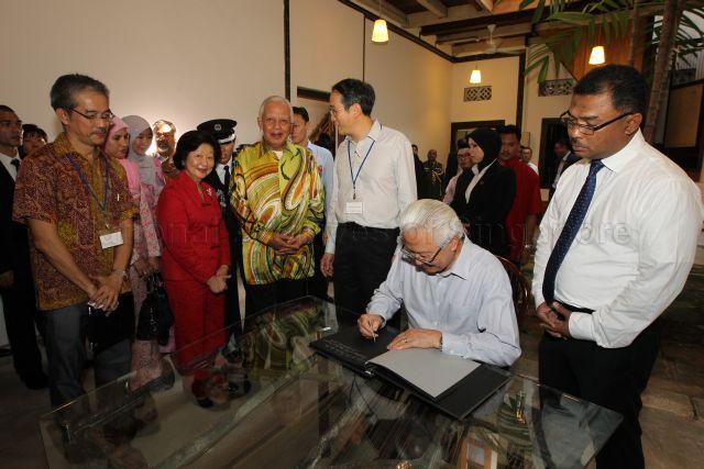 President Tony Tan signing a guest book at Tun Tan Cheng