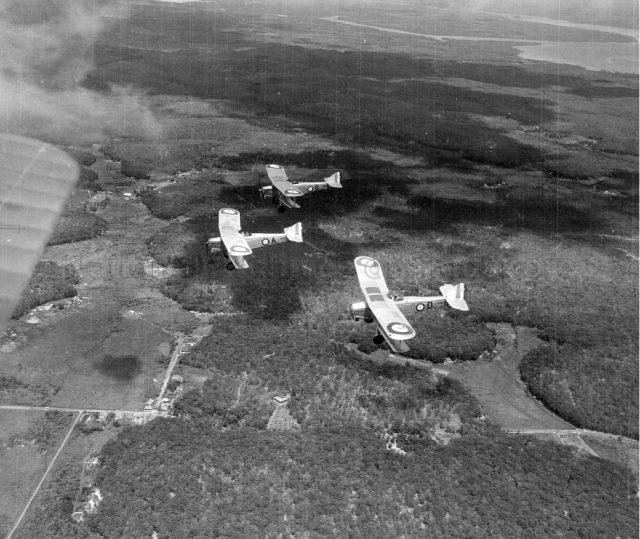 Aerial photograph of three aircraft in flight formation.
