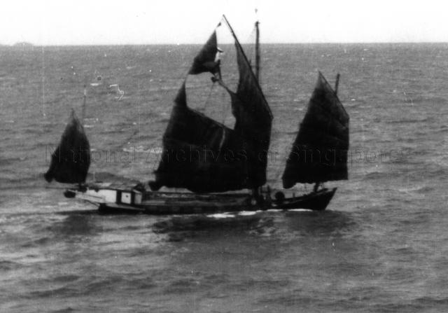 Photograph of a Chinese junk with torn sails