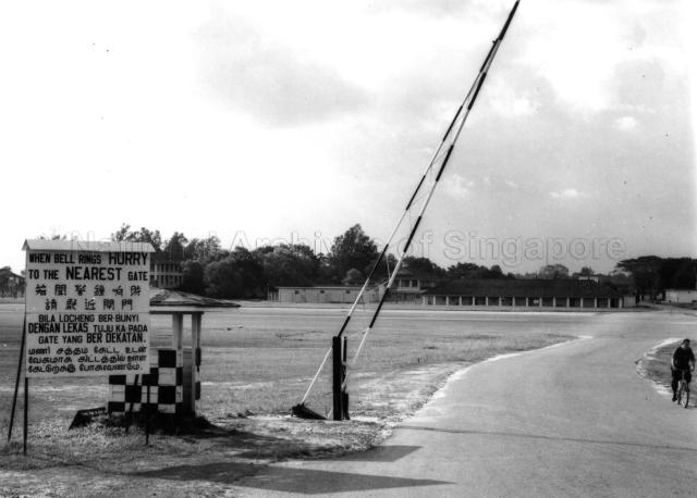 Photograph of a runway crossing with a warning sign in four