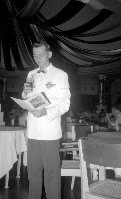 Photograph of John Finch studying the dinner menu