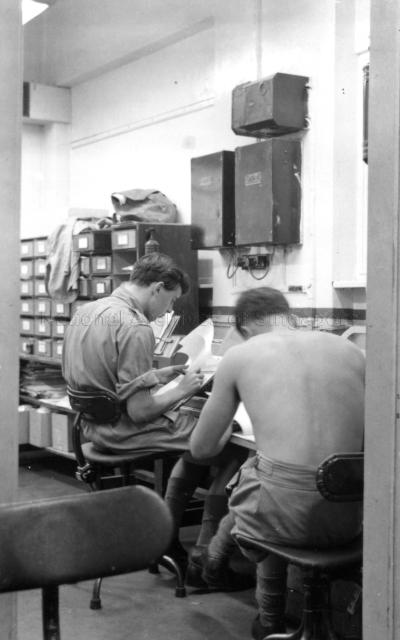 Photograph of two airmen working in the teleprinter cabin