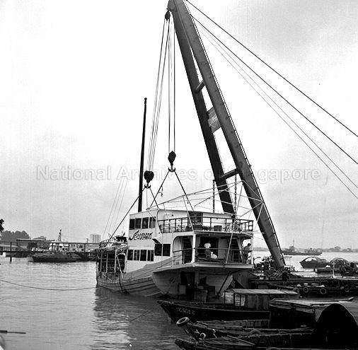 A GIANT FLOATING CRANE HAS RAISED THE 300-TON BOAT
